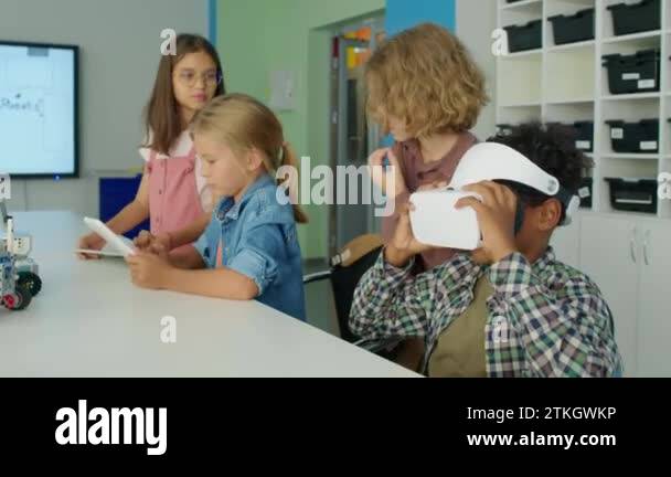 Medium shot of young African American boy putting on VR headset and ...