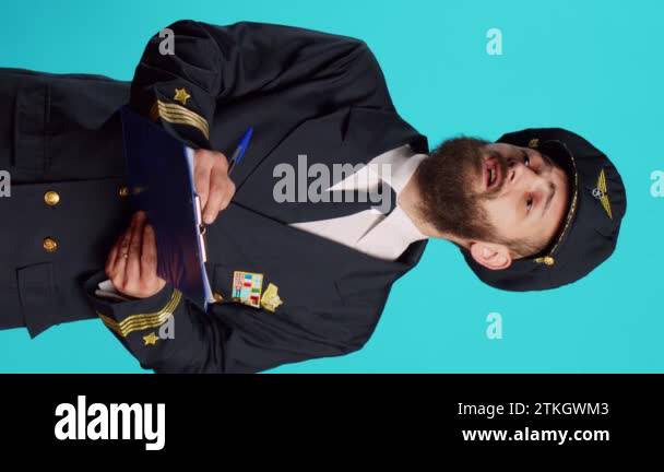 Vertical video: Confident aircrew captain checking list on papers ...