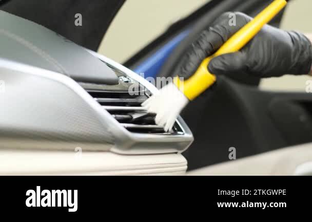 A car wash worker cleans the interior of a business class car ...