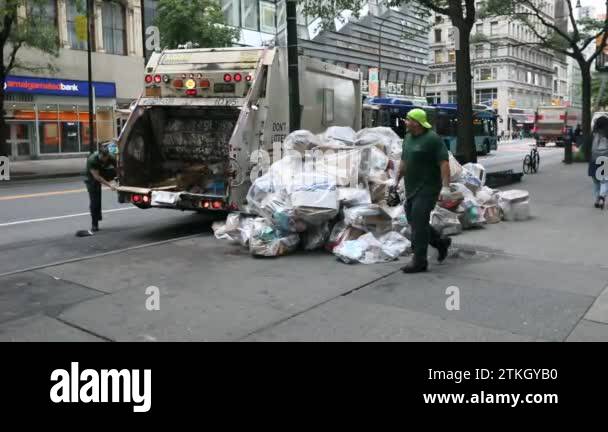Garbage Truck in NYC and two DSNY workers Loading White Plastic Garbage ...