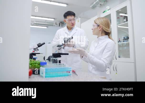 Surprised multiethnic scientists team looking at microscope and extremely happy after research ...