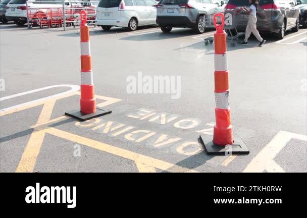 stack sticks tall orange white black pylons on top of loading zone ...