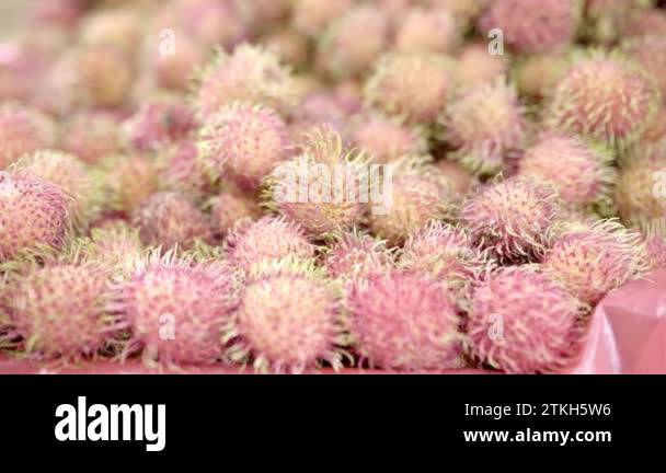 A stack of rambutan fruit in a Mexican street market. Close up. Concept ...