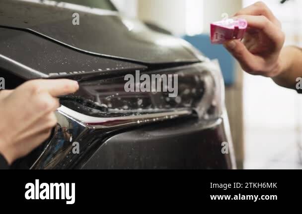 Close up to PPF installation process on a front headlight . PPF is a ...