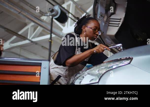 Trained serviceman in repair shop using torque wrench to tighten screws ...