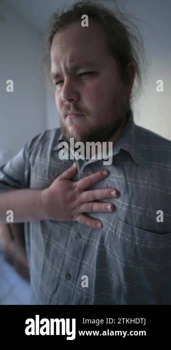 Unwell young man having chest pains unable to breath. One fat ...