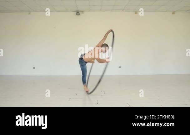 Real time full body of flexible male artist moving around steel cyr ...