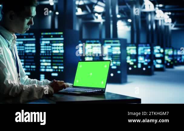 Asian technician using mockup laptop to implement artificial intelligence parallel processing ...