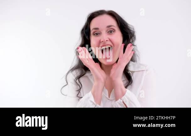 Young brunette woman opened her mouth put her hands to her face and ...