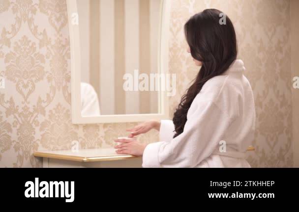 A close up side view of a pretty young brunette in white gown sitting ...