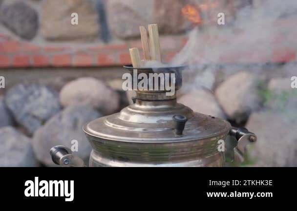 Traditional russian wood-burning samovar with smoke. Tea party on ...