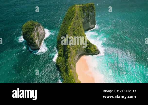 Rocky ocean shore with golden sandy beach Kelingking on Nusa Penida ...