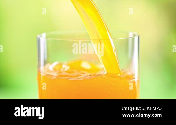Super Slow Motion Detail Shot of Pouring Fresh Orange Juice into Glass ...