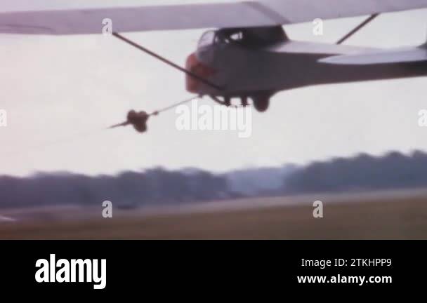 Historic glider starts take-off towed by winch with an assistant ...