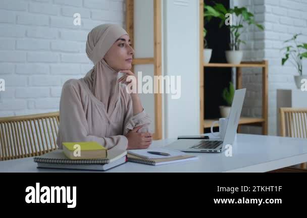 A young student is a beautiful woman in a hijab who is studying ...