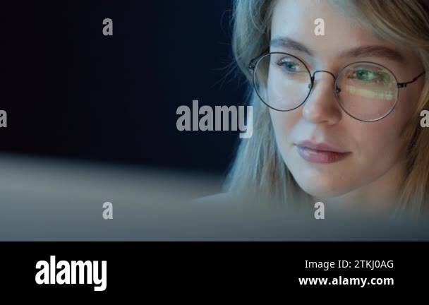 Panning right close up of cheerful woman sitting in front of computer ...
