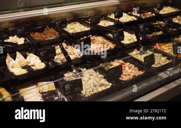 Food preparation, portions of ready-made food laid out in a supermarket ...