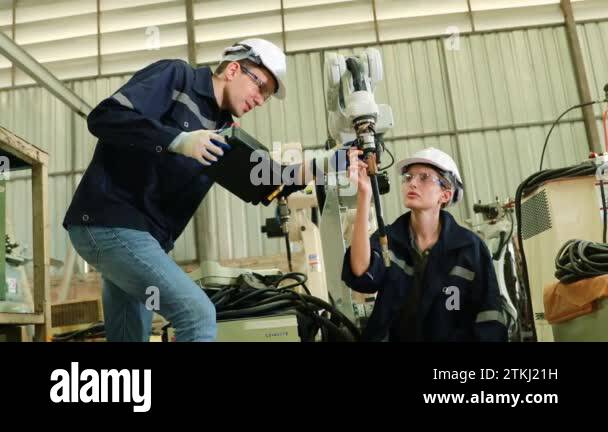 Two caucasian engineers electrical electronic man and woman set up program and inspect ...