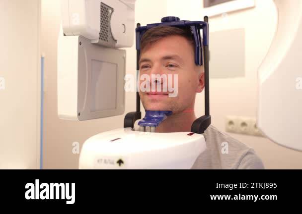 Dental x-ray machine with a cephalometric socket, an man takes a ...