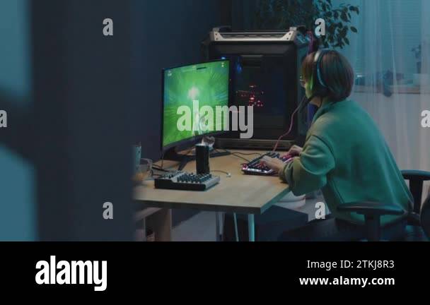 Medium shot of young Chinese woman sitting in front of computer at home ...
