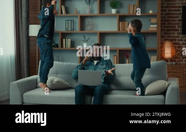 Angry stressed African American ethnic father man work with laptop ...