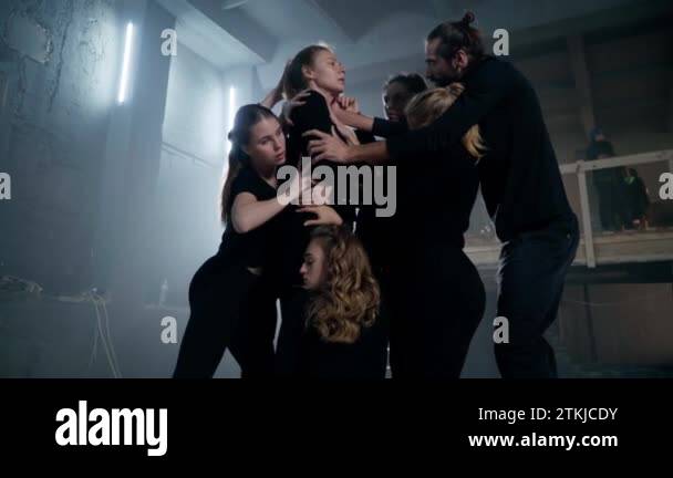 Zoom out from young Caucasian men and women stretching hands to lady ...