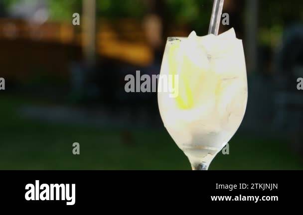 pour lemonade with ice Ice into a glass pour soda water throw lemon ...