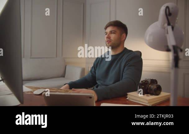 Man looking at camera, holding conversation with team online ...