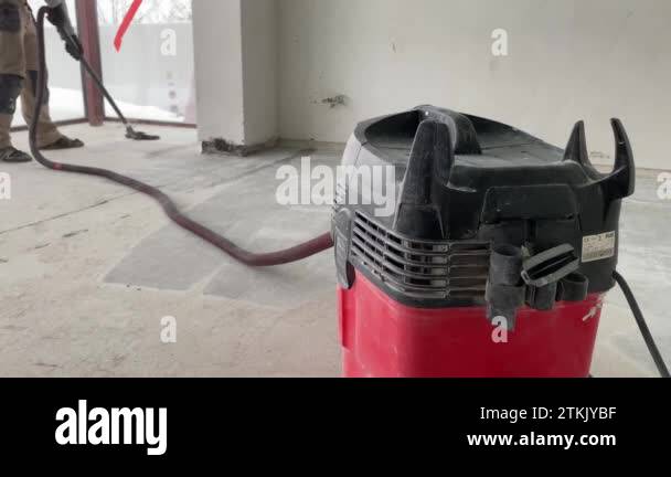 Construction works. The builder removes dust and small debris from the ...