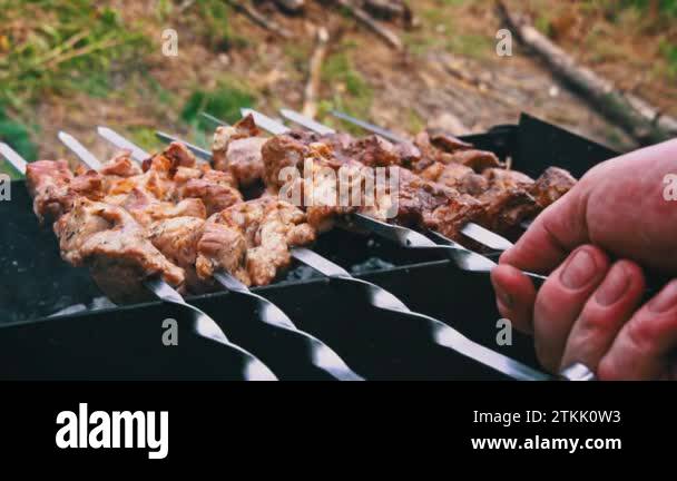 Kebab is fried on skewers in the grill and turned over. Juicy beautiful ...