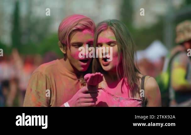Portrait of cheerful and joyful guys who have fun at the festival of colors Holi. A guy and a ...