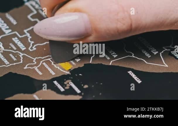 Scratching country of Tanzania on the surface of a scratch world map ...