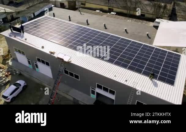 Modern solar panels produce clean electricity. Solar technician installing solar panels on house ...