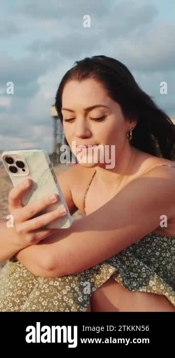 VERTICAL VIDEO: Couple in love meets sunrise on the beach. Back view ...