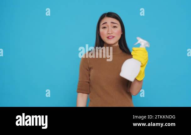 Professional maid pointing and showing cleaning product or isolated ...