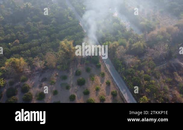 Aerial view of a rural village with smoke from burning activities ...