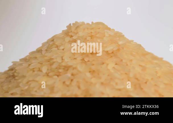 Dry Uncooked Parboiled Rice Heap Rotating against White Background. A ...