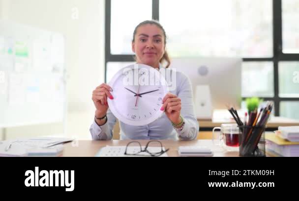 Woman with a large round wall clock in office. Employee manager and ...