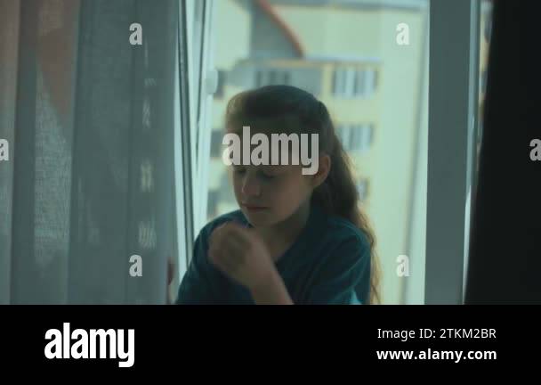 Sad little girl crying and wiping tears with hands while sitting alone ...