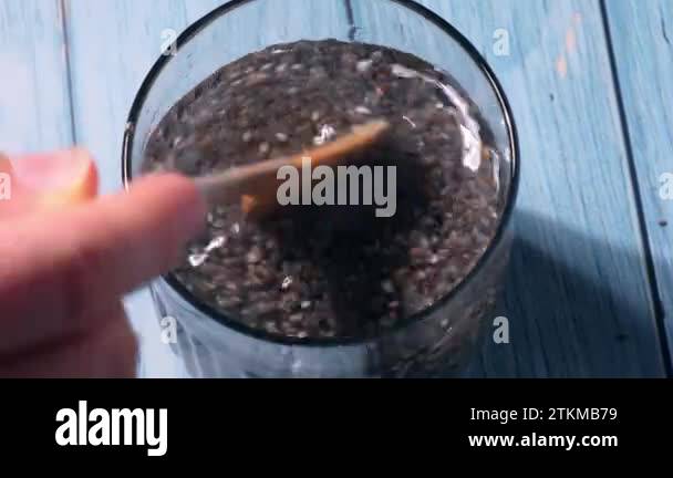 Preparing superfood water drink rich in Omega 3 fatty acids. Pouring ...