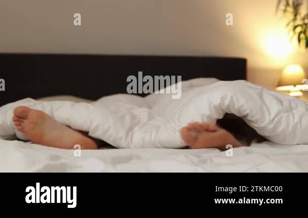 Scared young Caucasian woman wakes up in bed in horror from terrible ...