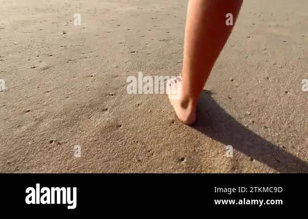 Footprints in the sand on the beach. The camera follows footprints of ...