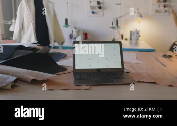 Full arc shot of laptop with empty white screen on table of fashion ...