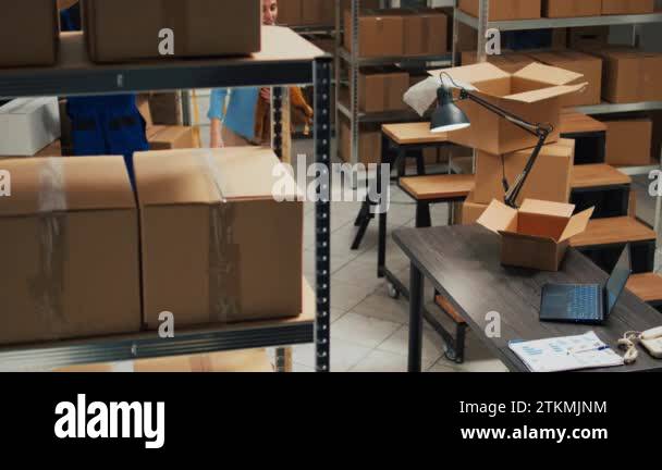 Woman employee taking supplies from warehouse shelves and putting them ...