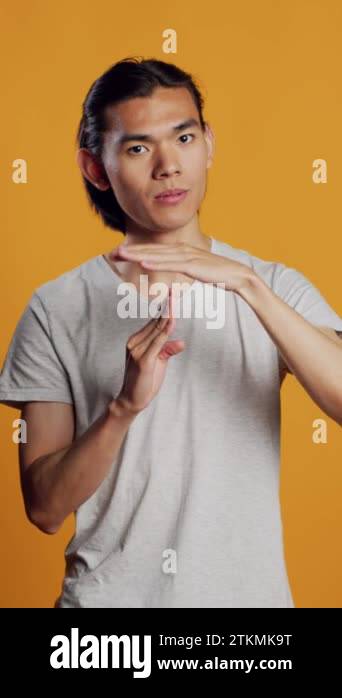 Vertical video: Young adult doing t shape symbol on camera, showing ...