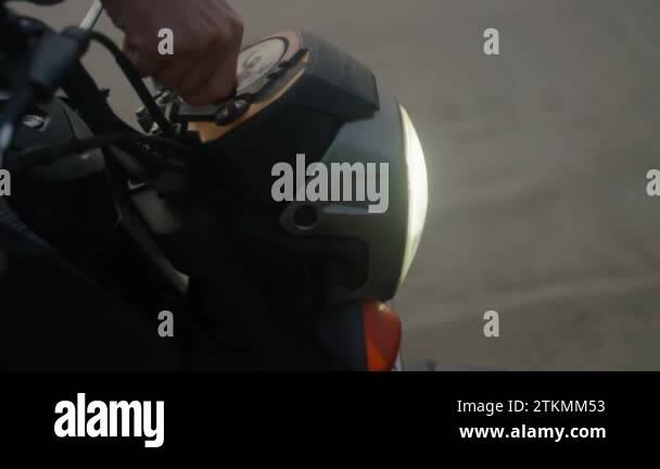Biker hand inserts the key into ignition of the motorcycle and turns it ...