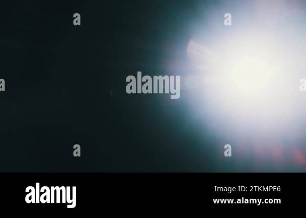 Point light of a bright flashlight directed at the camera on black ...