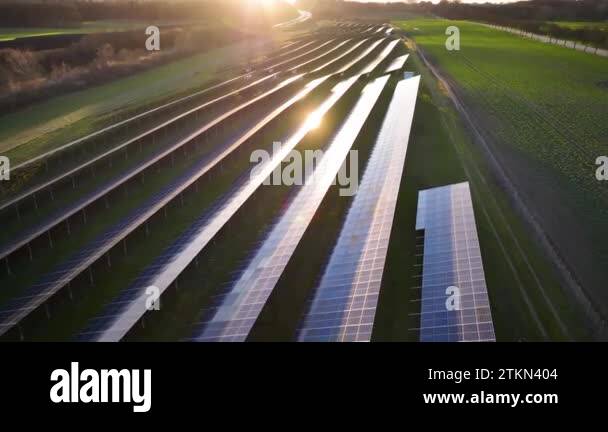 Aerial footage of photovoltaics on open spaces against sunset. The ...