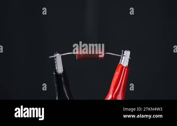 The resistor heats up with smoke under a high electric current, short ...