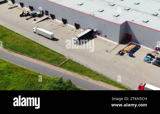 Semi-trailer trucks stand at the ramps of warehouse in the logistics ...